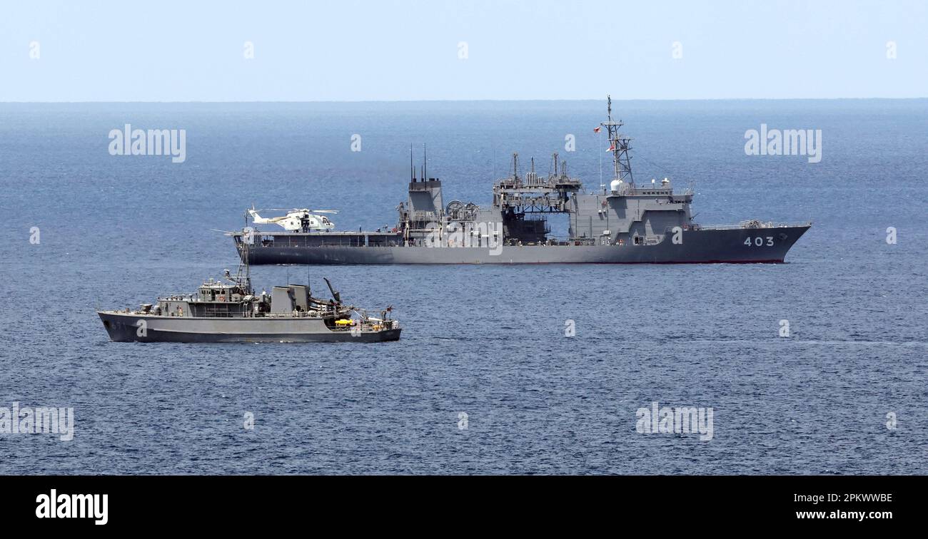 The Shishijima (background), a minesweeper vessel, and the Chihaya, a ...