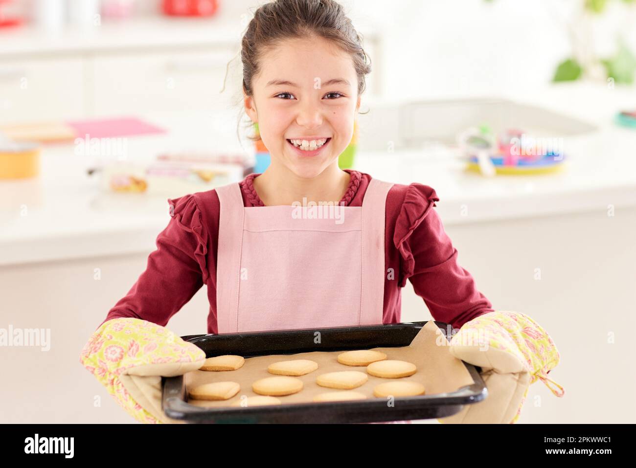 Smiling young girl making sweets Stock Photo - Alamy