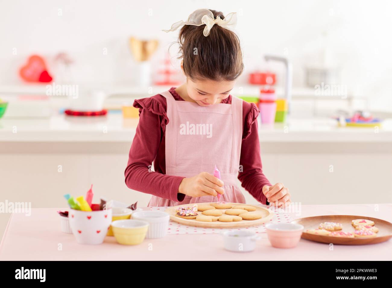 Smiling young girl making sweets Stock Photo - Alamy
