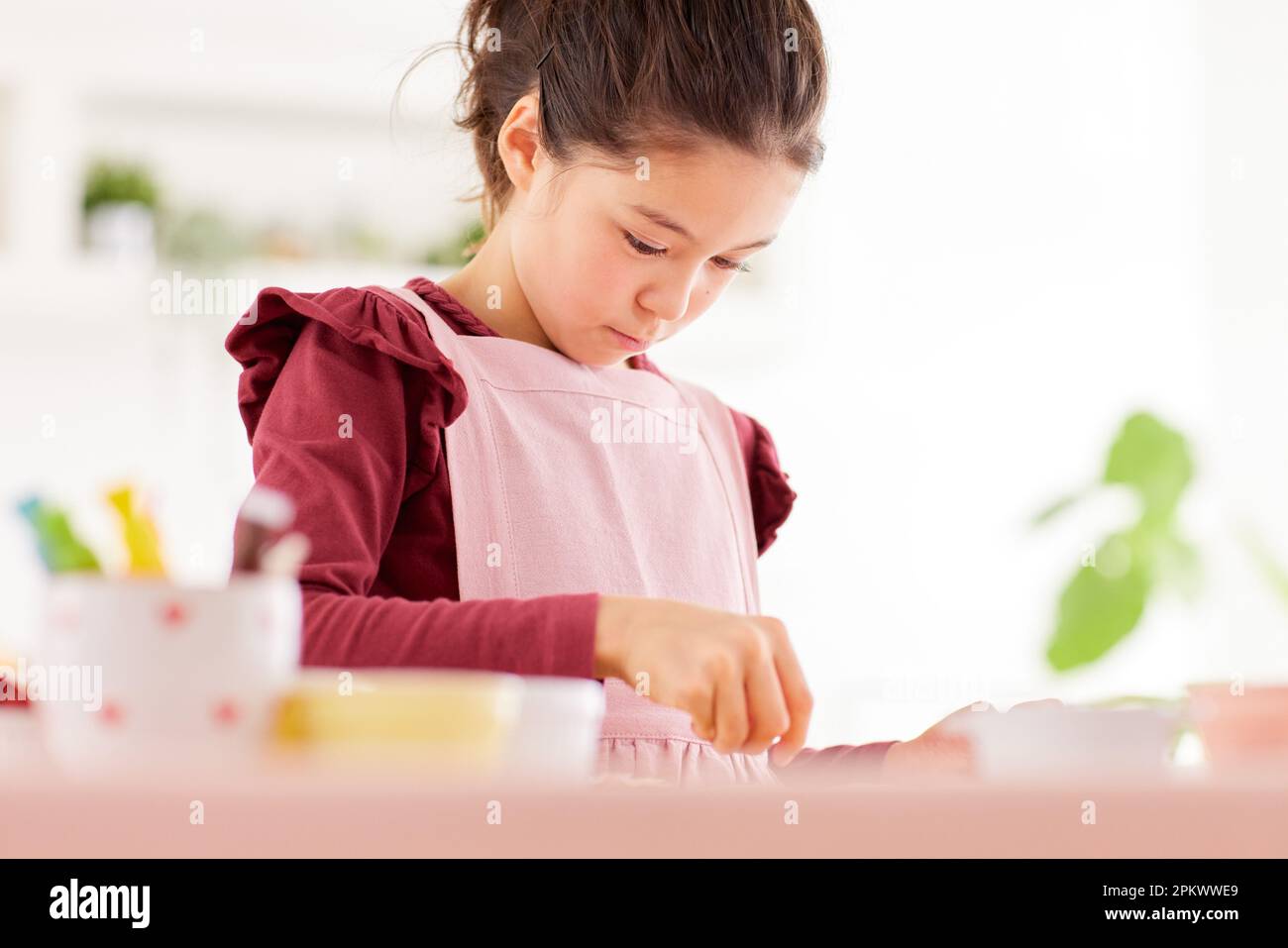 Smiling young girl making sweets Stock Photo - Alamy