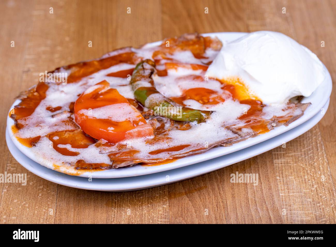 iskender kebab. iskender kebab with butter and yoghurt on a wooden ...