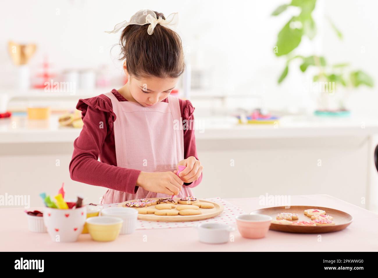 Smiling young girl making sweets Stock Photo - Alamy