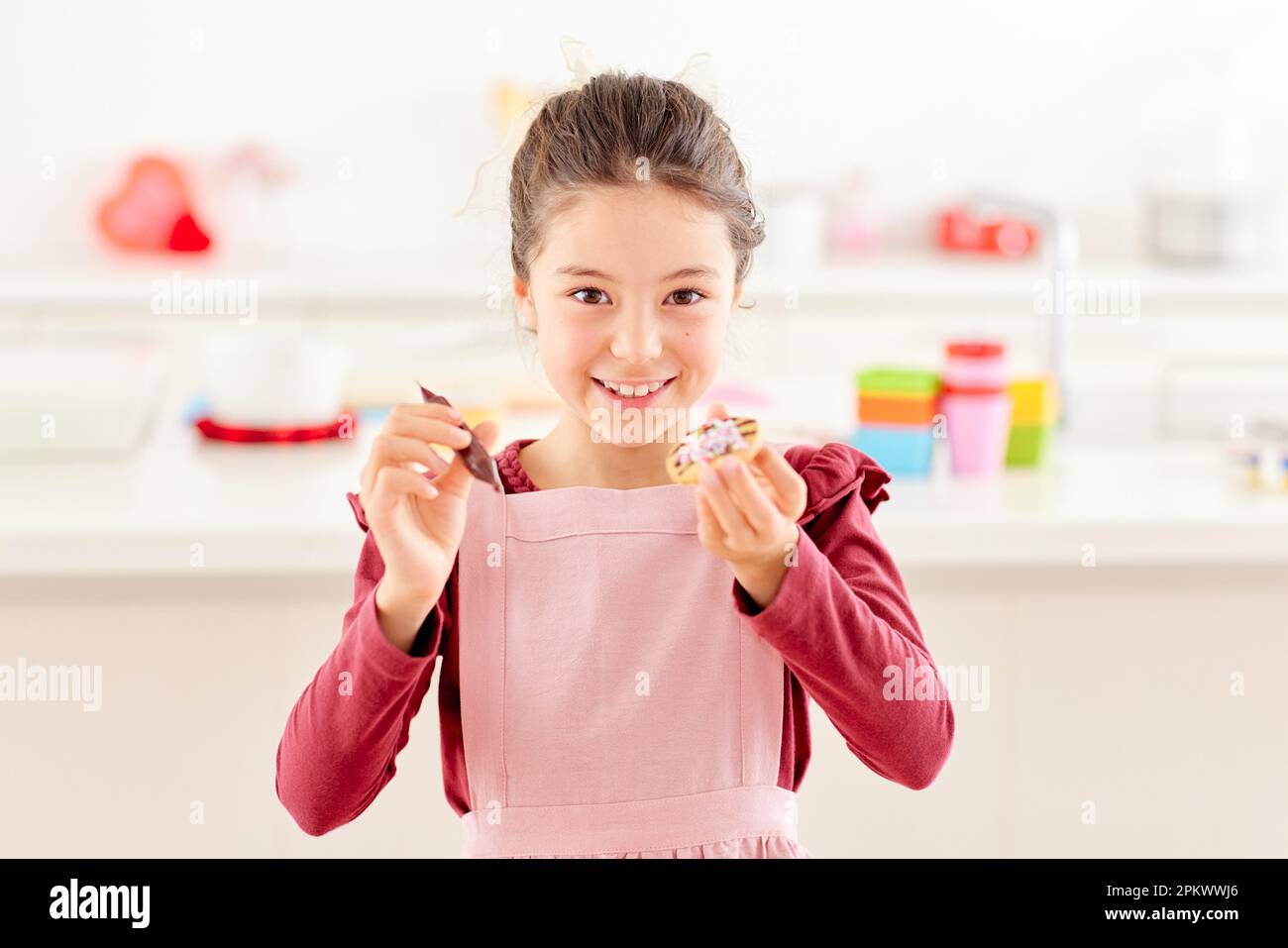 Smiling young girl making sweets Stock Photo - Alamy