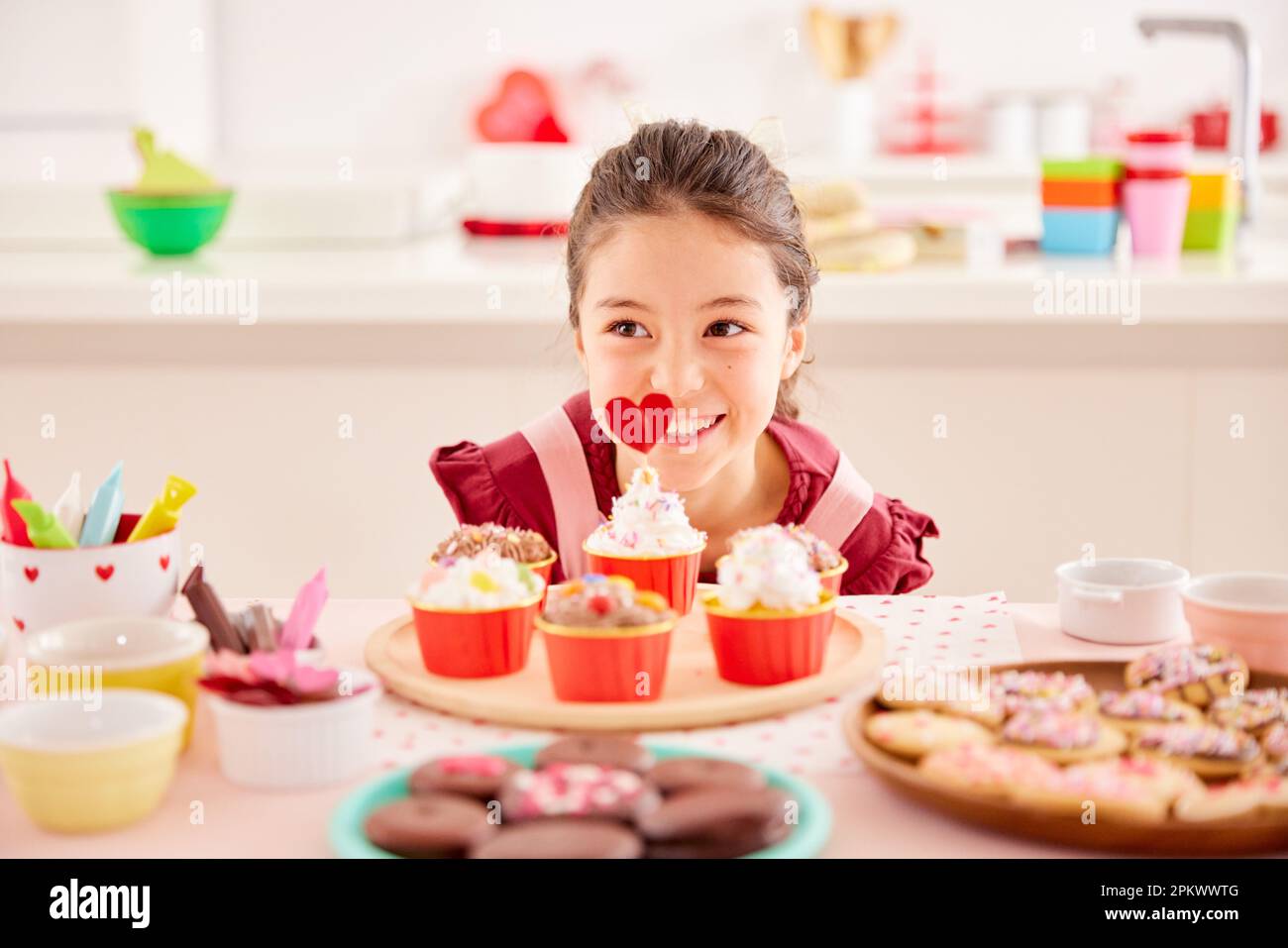 Smiling young girl making sweets Stock Photo - Alamy