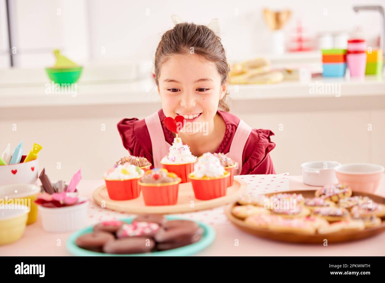 Smiling young girl making sweets Stock Photo - Alamy