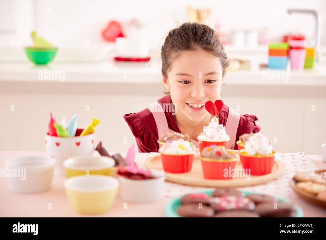 Smiling young girl making sweets Stock Photo - Alamy