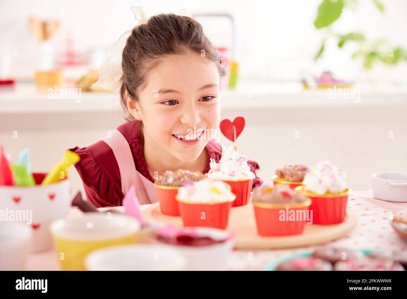 Smiling young girl making sweets Stock Photo - Alamy