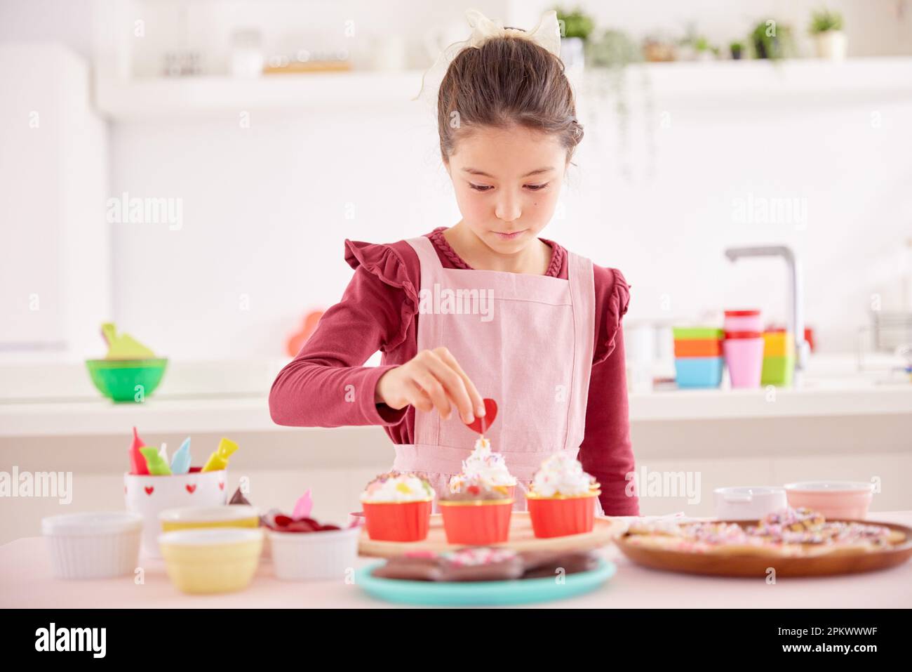 Smiling young girl making sweets Stock Photo - Alamy