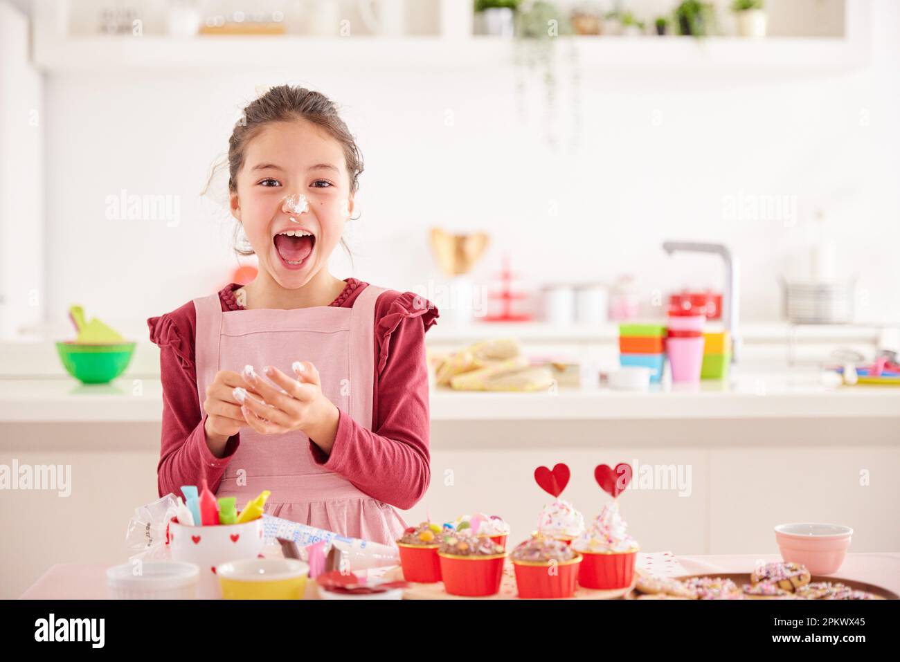 Smiling young girl making sweets Stock Photo - Alamy