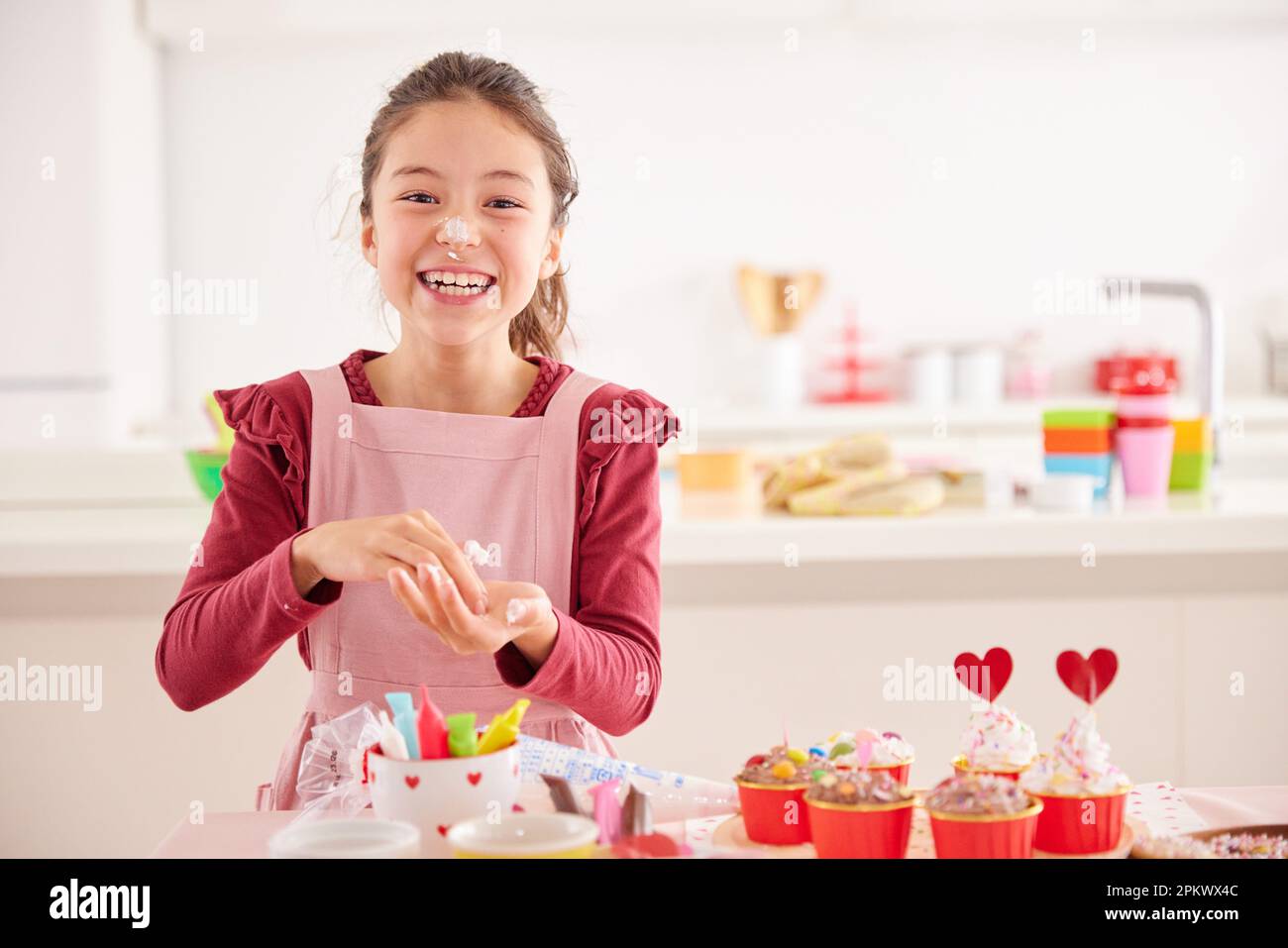 Smiling young girl making sweets Stock Photo - Alamy