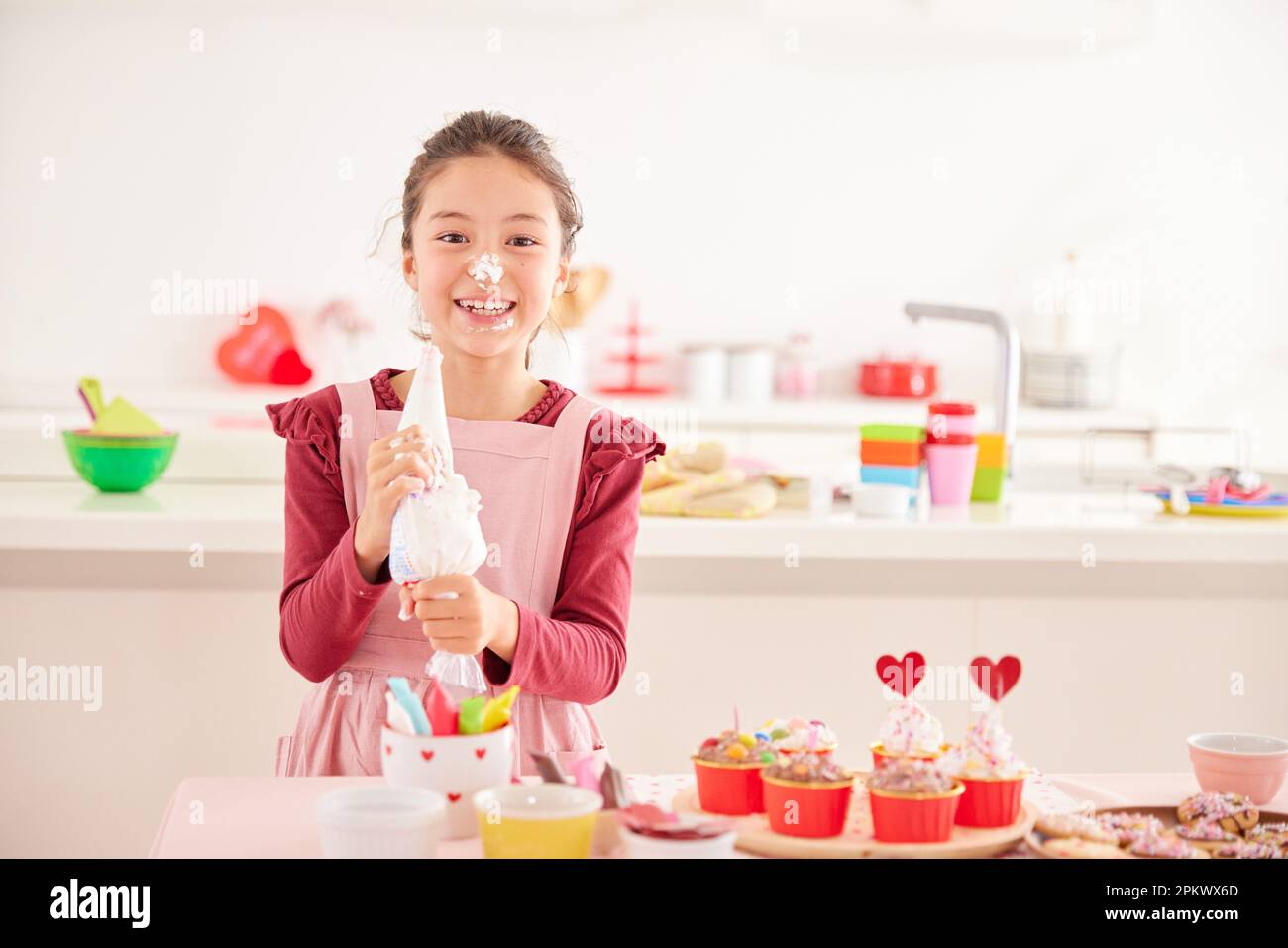 Smiling young girl making sweets Stock Photo - Alamy