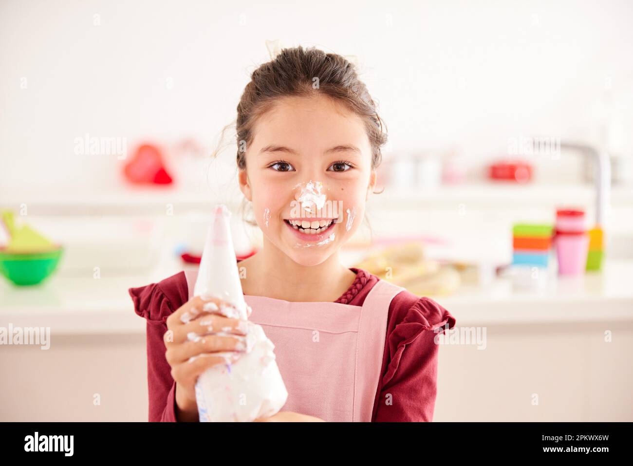 Smiling young girl making sweets Stock Photo - Alamy