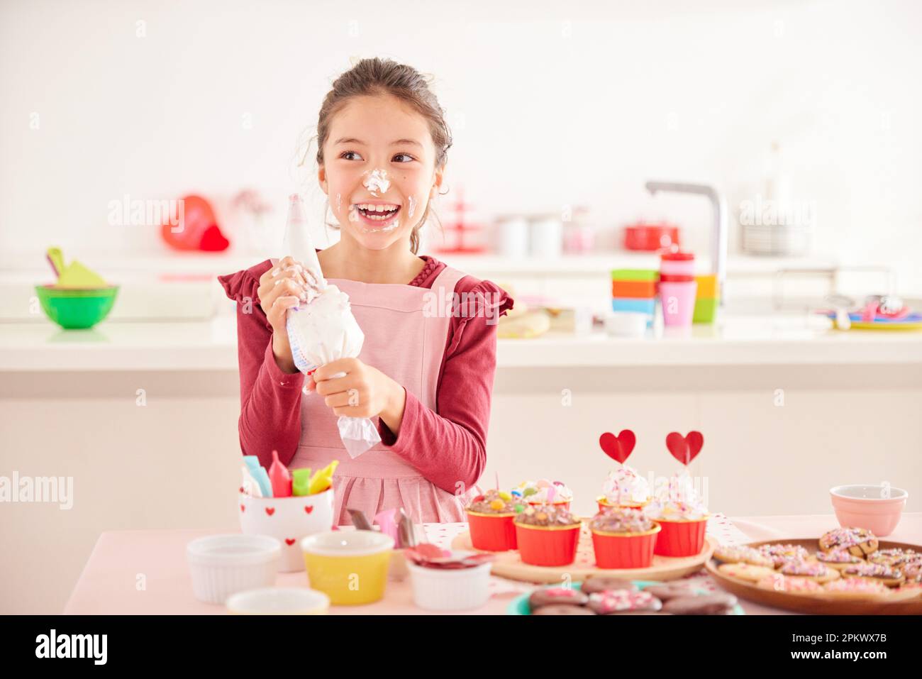 Smiling young girl making sweets Stock Photo - Alamy