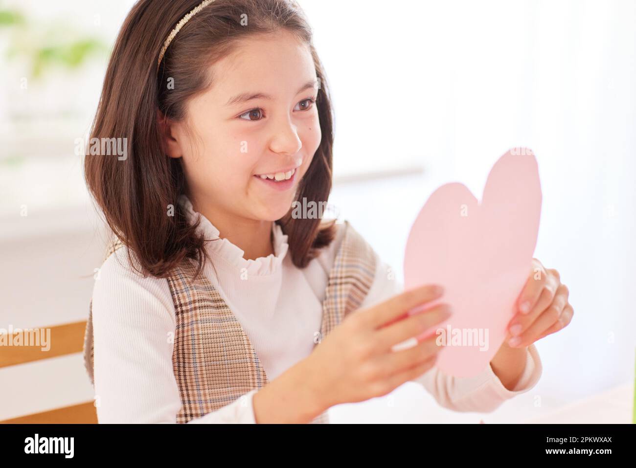 Smiling young girl playing with craft paper Stock Photo - Alamy