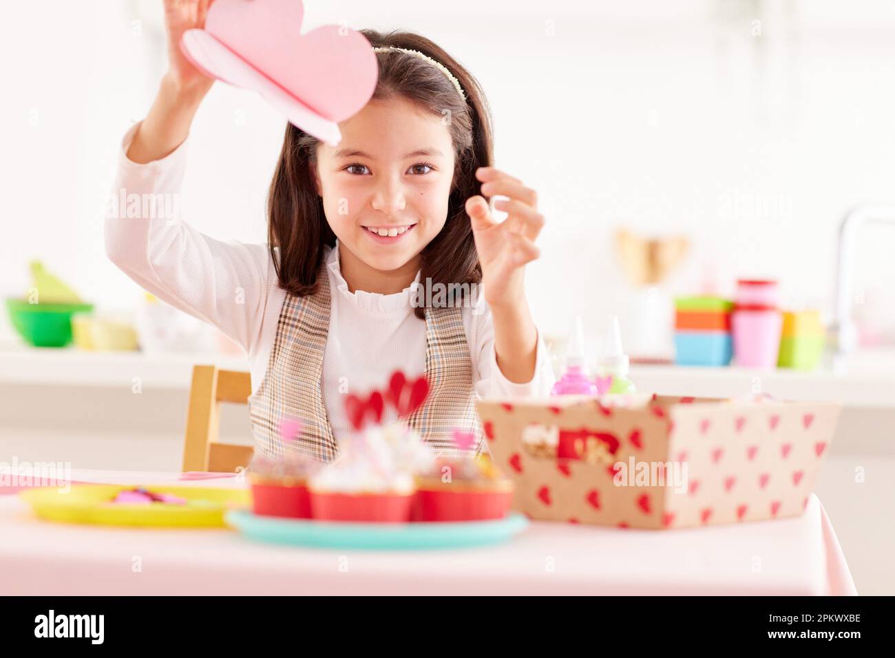Smiling young girl playing with craft paper Stock Photo - Alamy