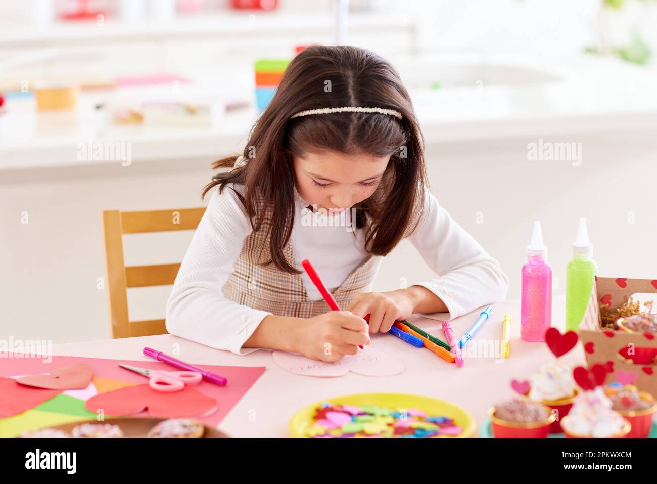 Smiling young girl playing with craft paper Stock Photo - Alamy