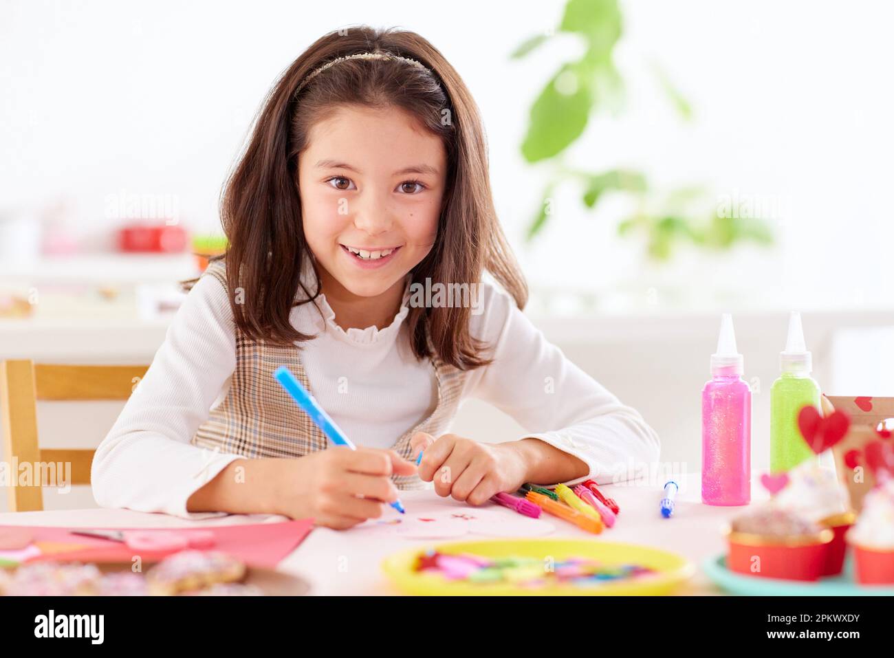 Smiling young girl playing with craft paper Stock Photo - Alamy