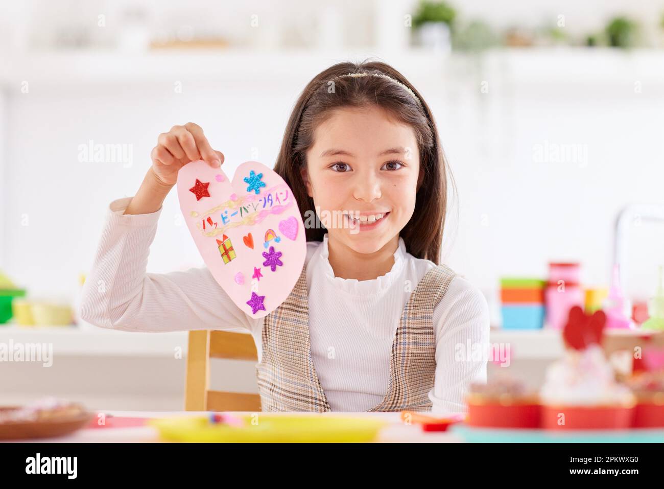 Smiling young girl playing with craft paper Stock Photo - Alamy