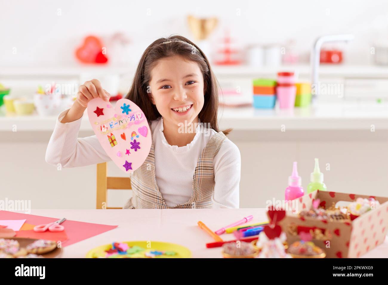 Smiling young girl playing with craft paper Stock Photo - Alamy