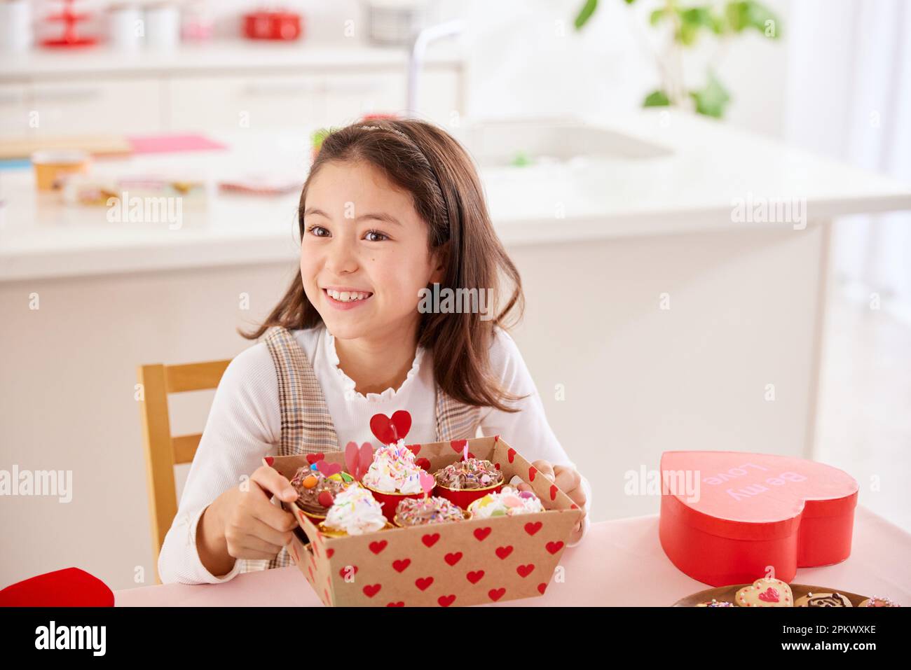 Smiling young girl making sweets Stock Photo - Alamy