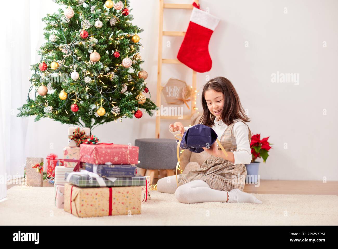 Smiling young girl opening Christmas presents Stock Photo - Alamy