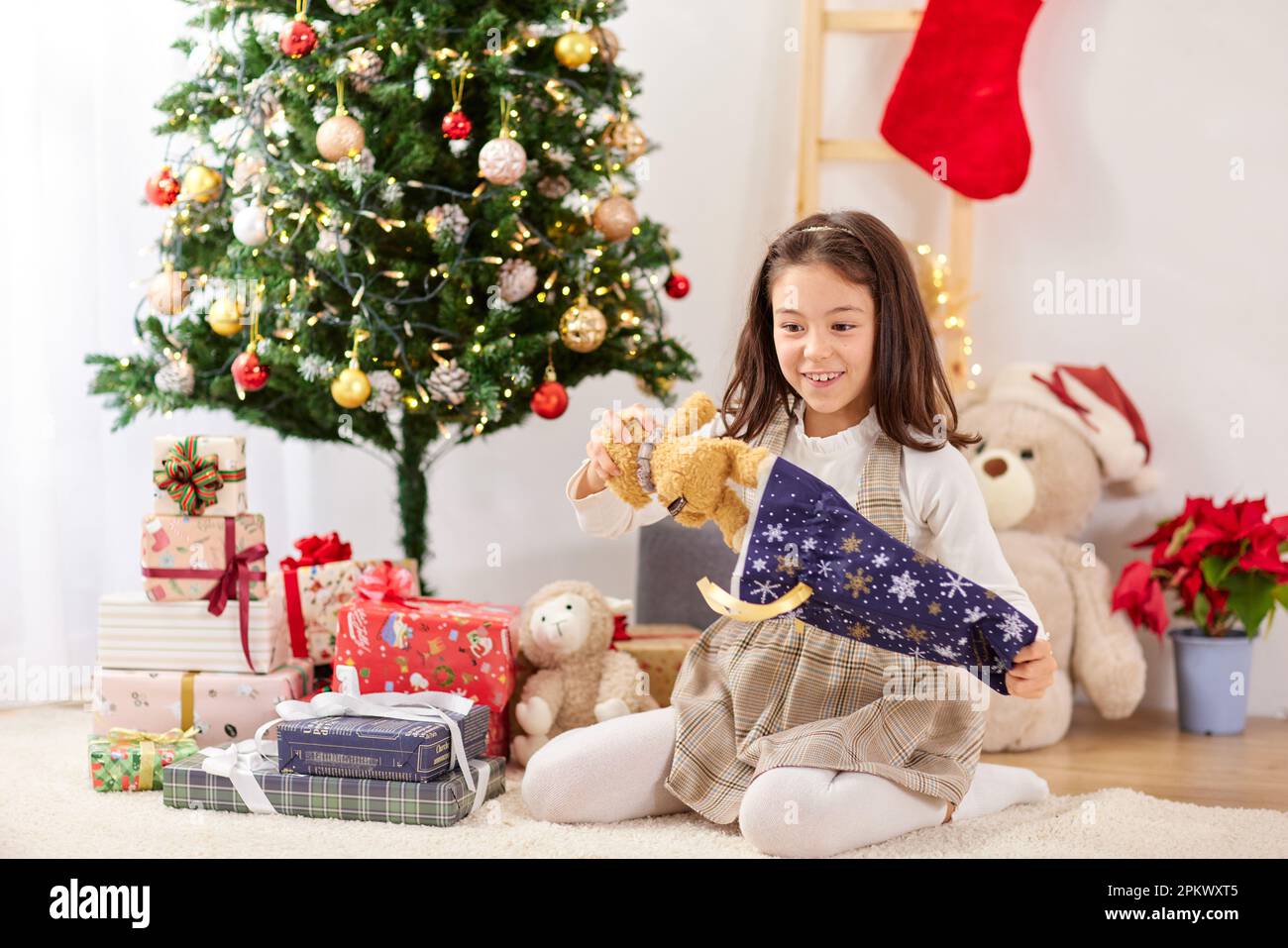 Smiling young girl opening Christmas presents Stock Photo - Alamy