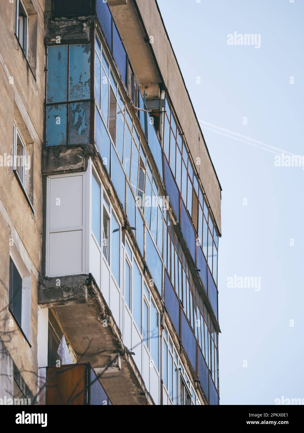 Worn out apartment building from the communist era against blue sky in ...