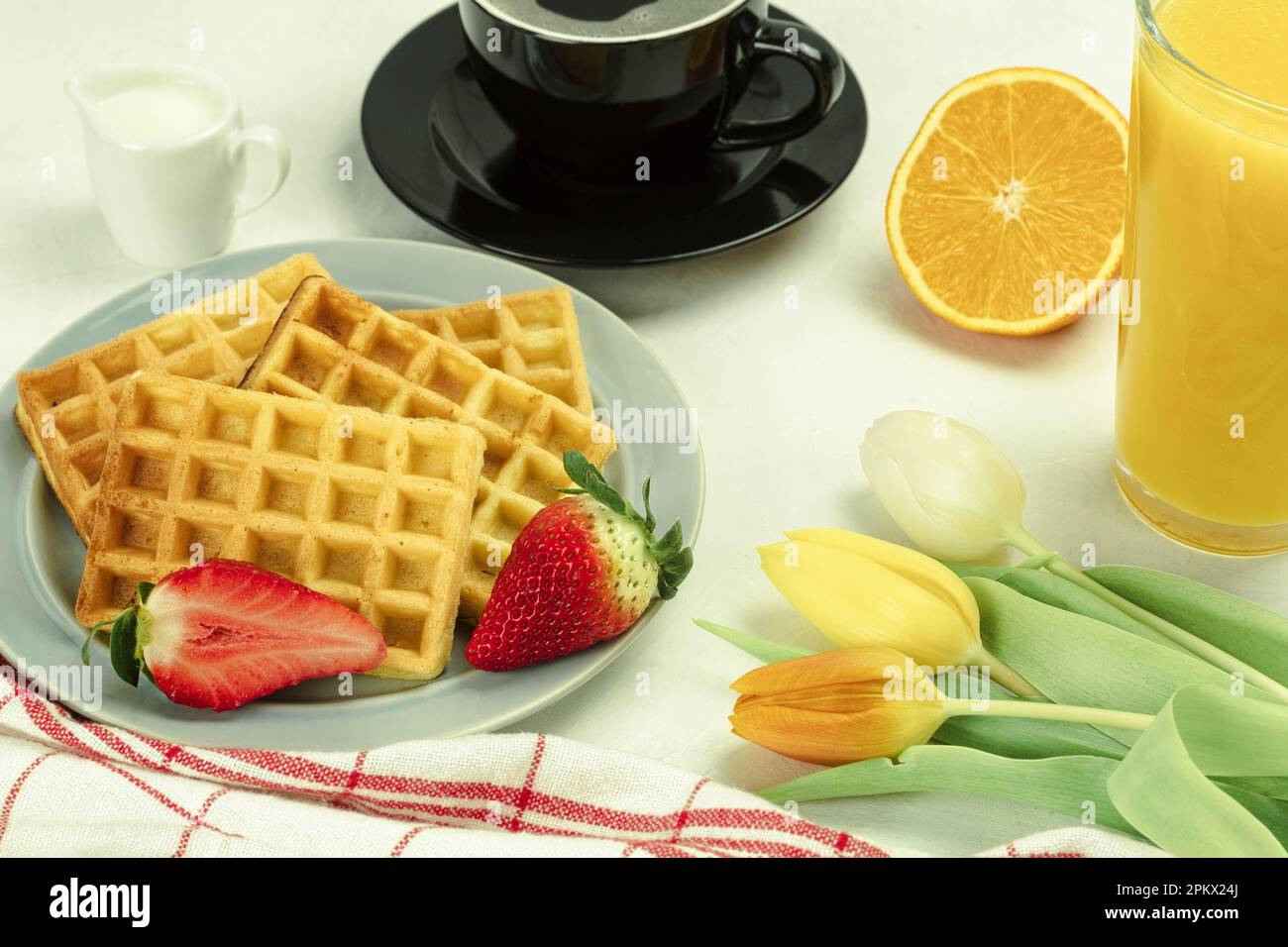 Fresh tulips and Belgian fruit waffles, top view. Tasty breakfast ...