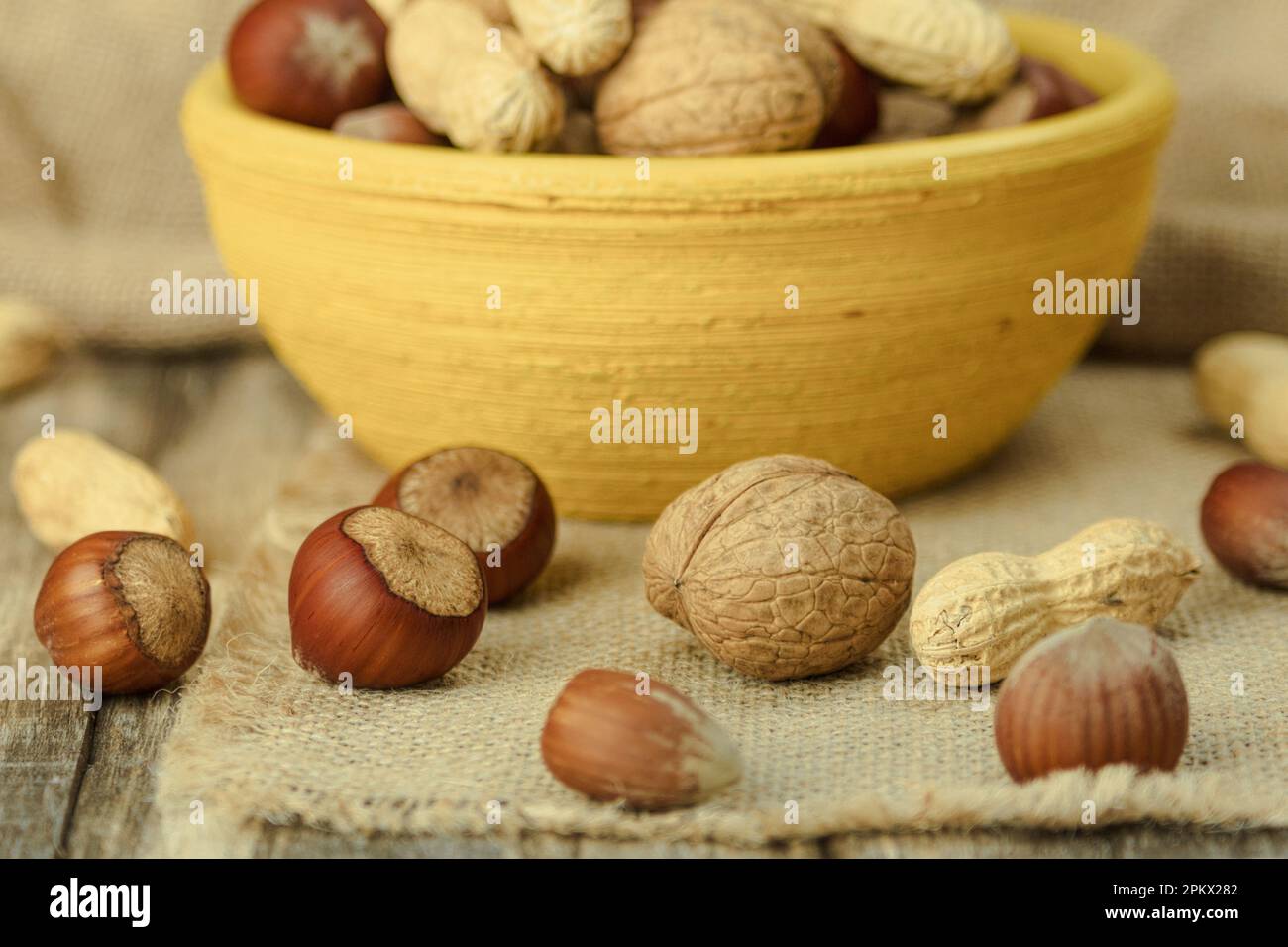 A mix of nuts in a shell, in a clay plate. A mixture of nuts on an old ...