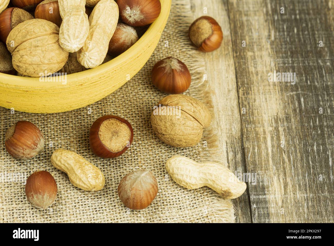 A mix of nuts in a shell, in a clay plate. A mixture of nuts on an old ...