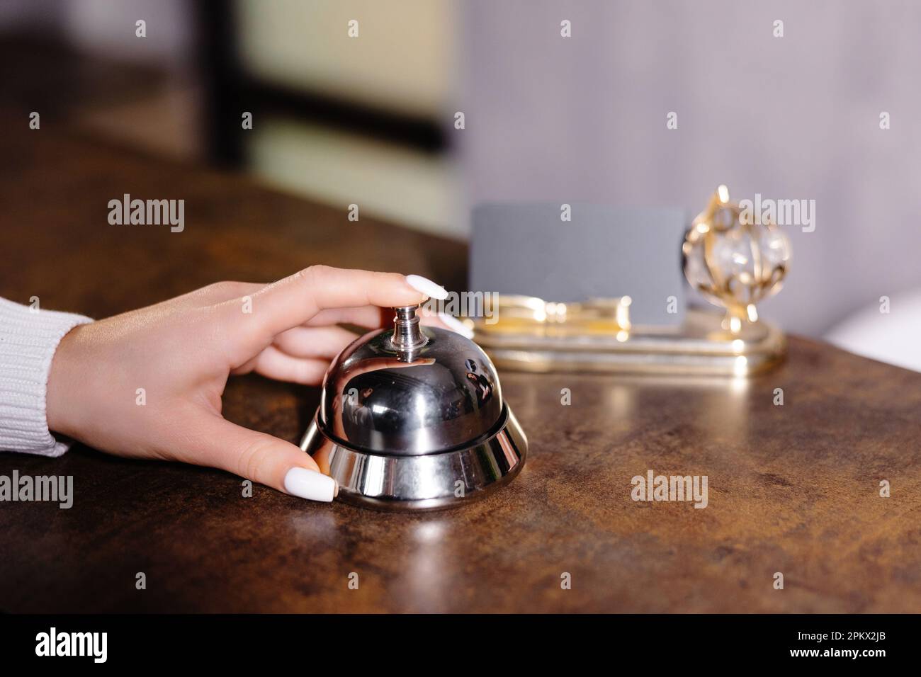 Hand of guest ringing bell on reception desk of in hotel Stock Photo ...