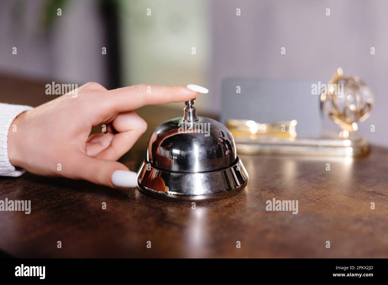 Hand of guest ringing bell on reception desk of in hotel Stock Photo ...