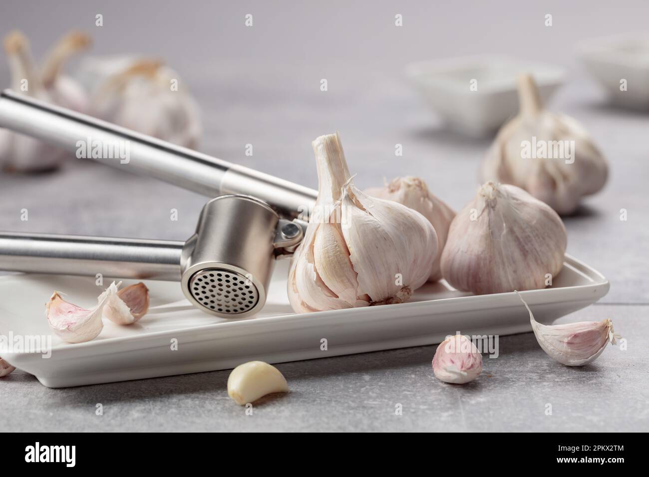 Garlic and garlic press on a grey stone table Stock Photo - Alamy