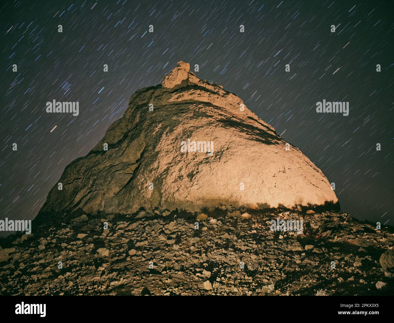 Illuminated rock formation at the Trona Pinnacles at night with stars ...