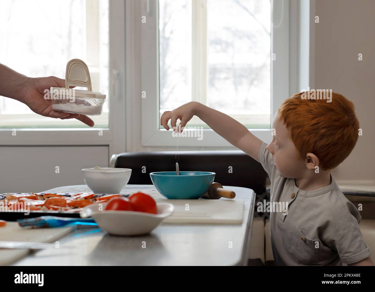 Child cooks with dad. The kid pours salt into a plate Stock Photo - Alamy
