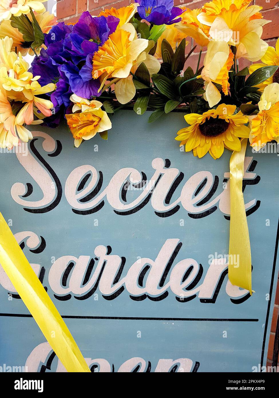 Advertising sign with colourful flowers above Stock Photo - Alamy