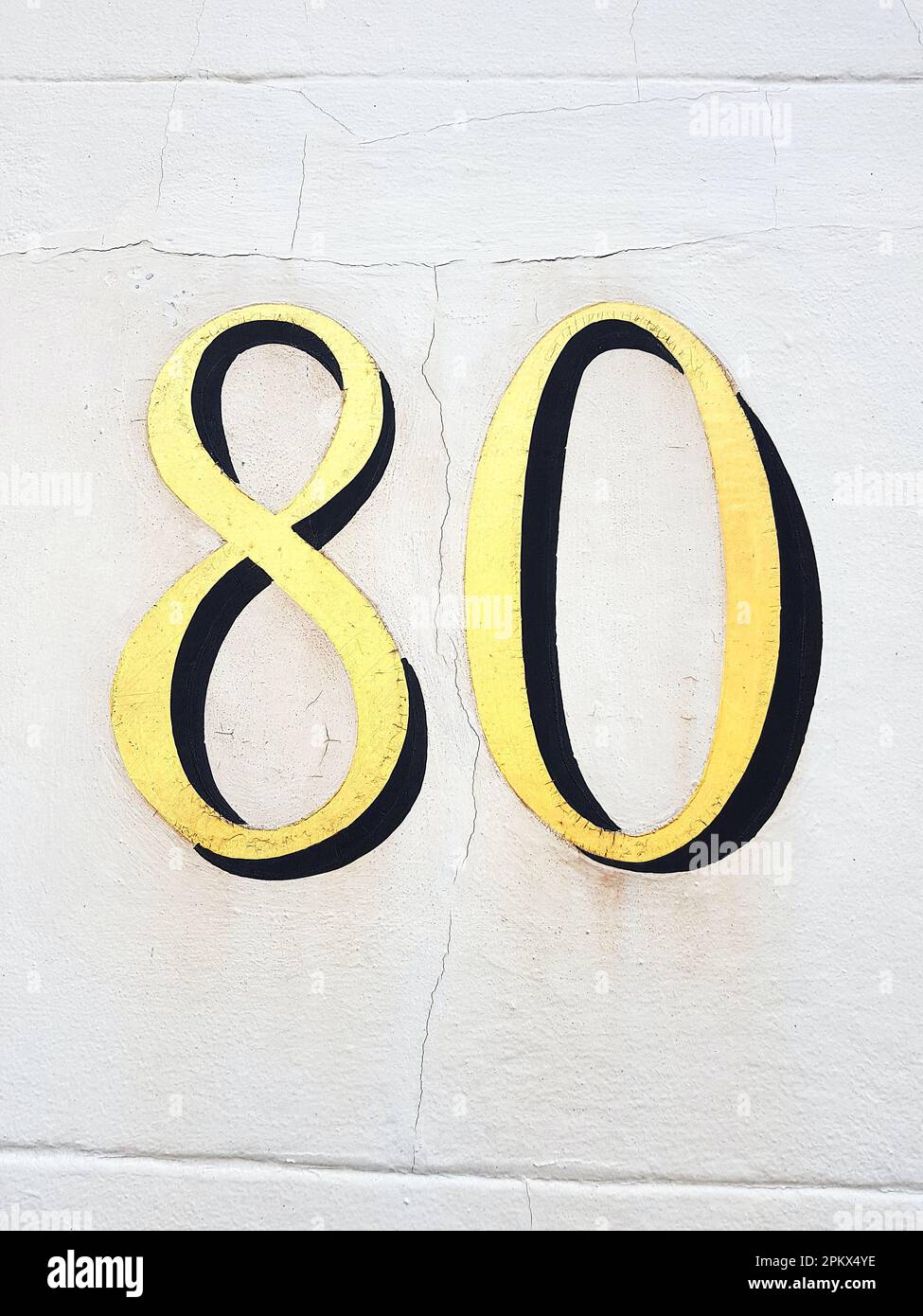 The number 80 in gold paint with a black drop shadow Stock Photo - Alamy