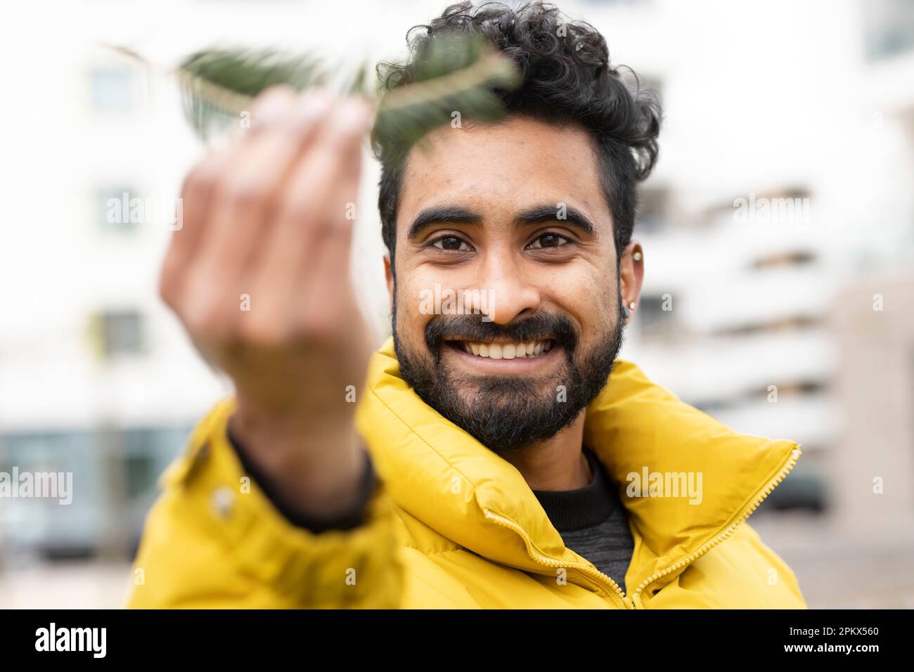 Young man holding a green blanch in the hand outside Stock Photo - Alamy