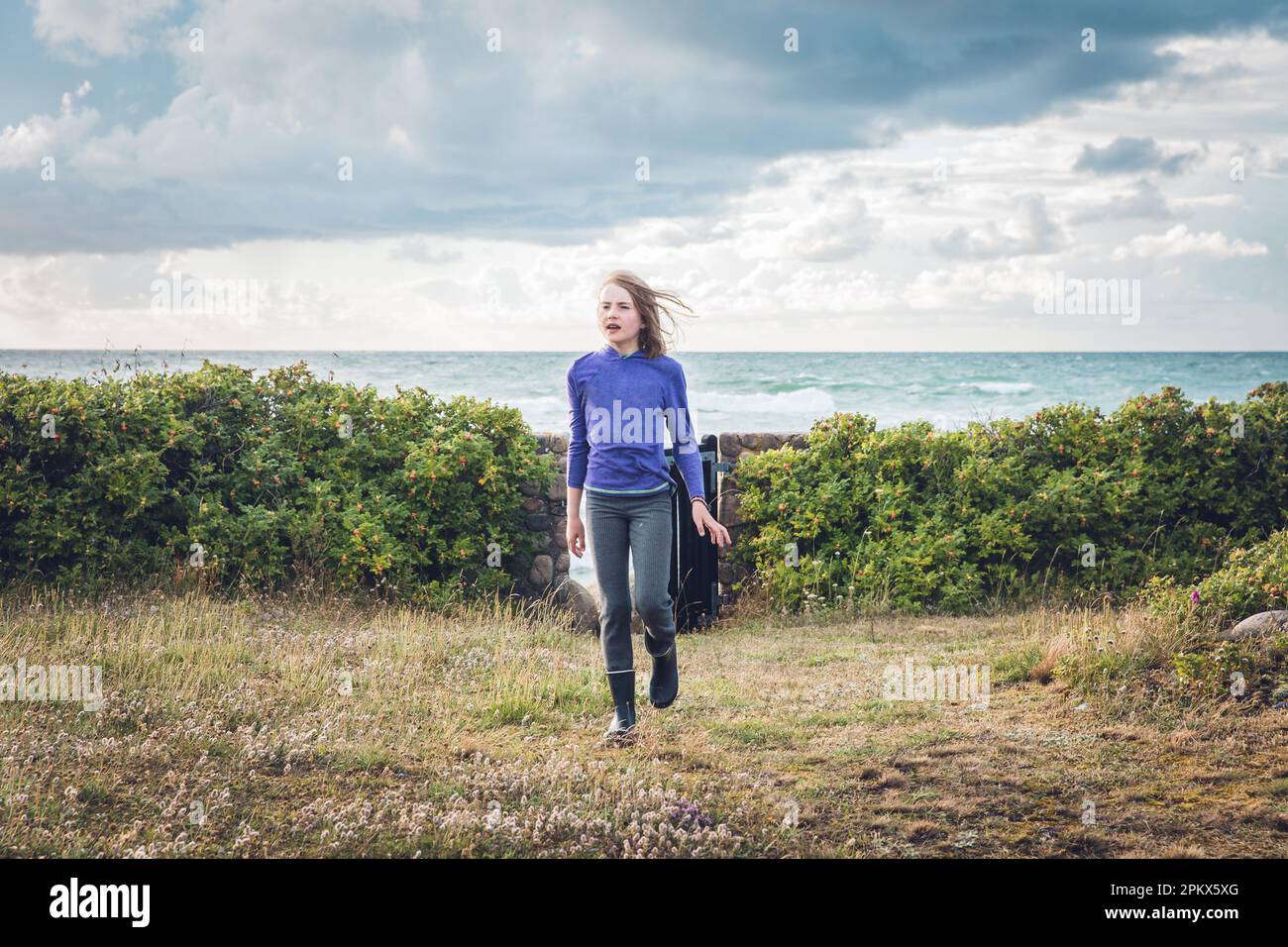 Dramatic Seascape and Young Girl Walking Stock Photo - Alamy