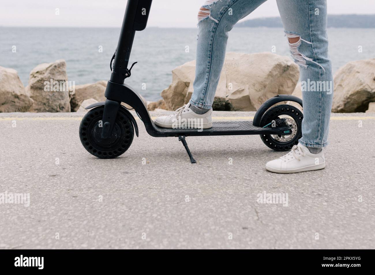 Attractive girl riding an electric scooter along the promenade Stock ...