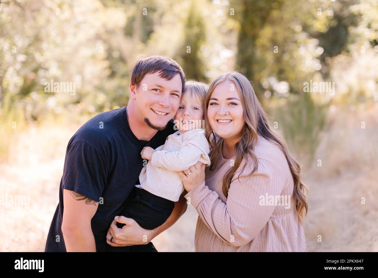 Happy family of 3, faces close together, outside Stock Photo - Alamy