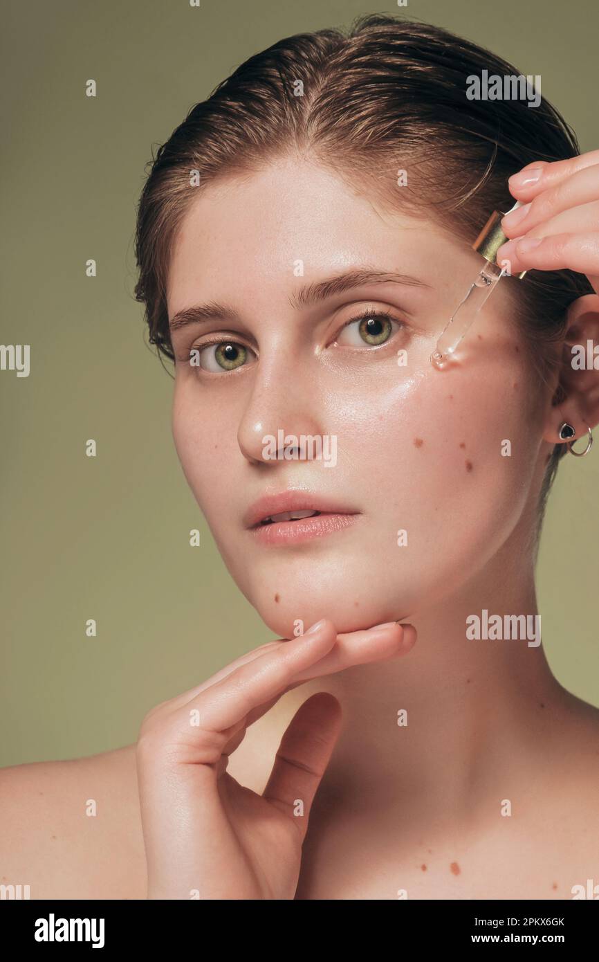 Close up model with hydrated facial skin and natural makeup on green ...