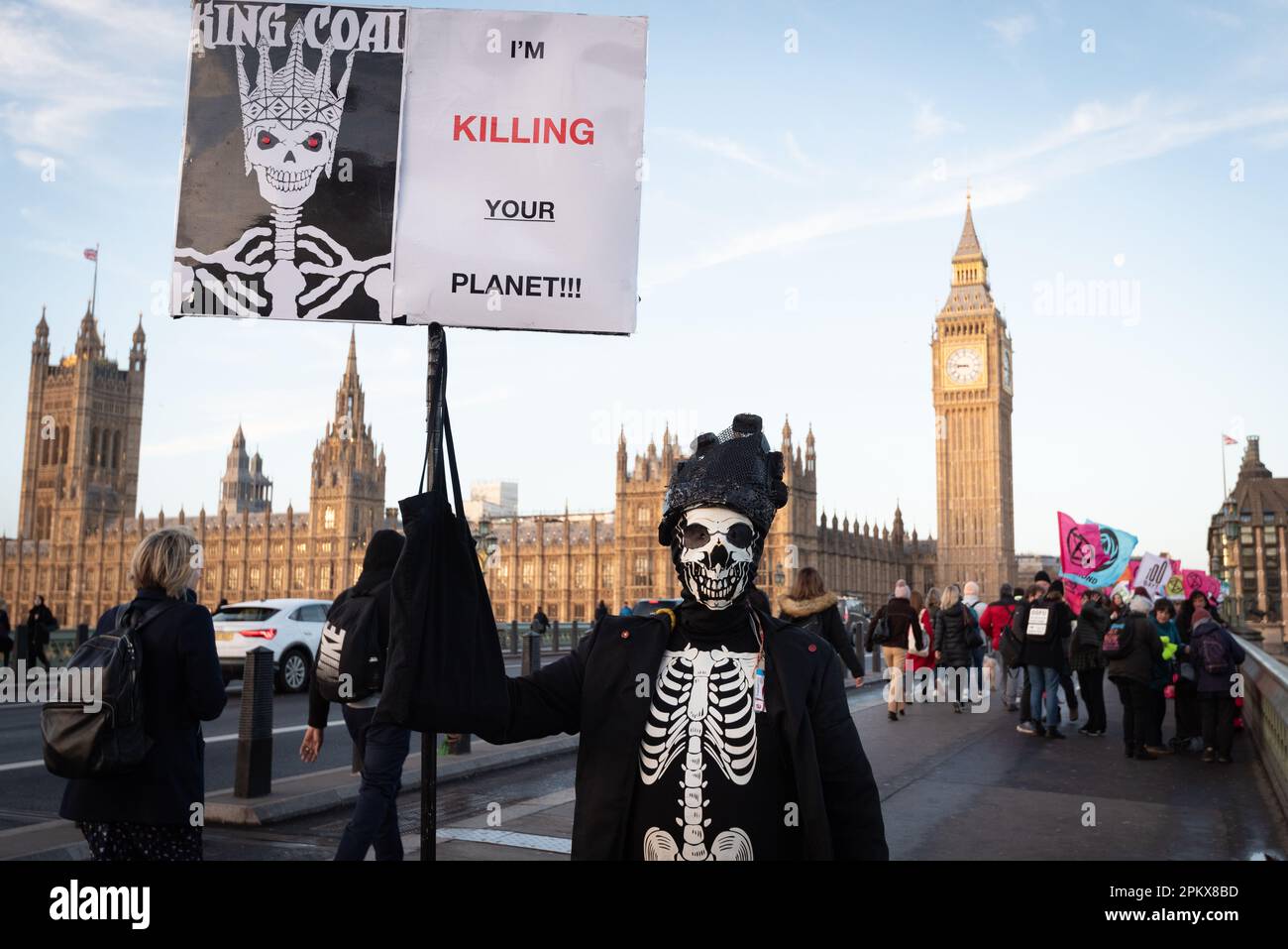 A climate activist stands on Westminster Bridge, wearing a skeleton ...