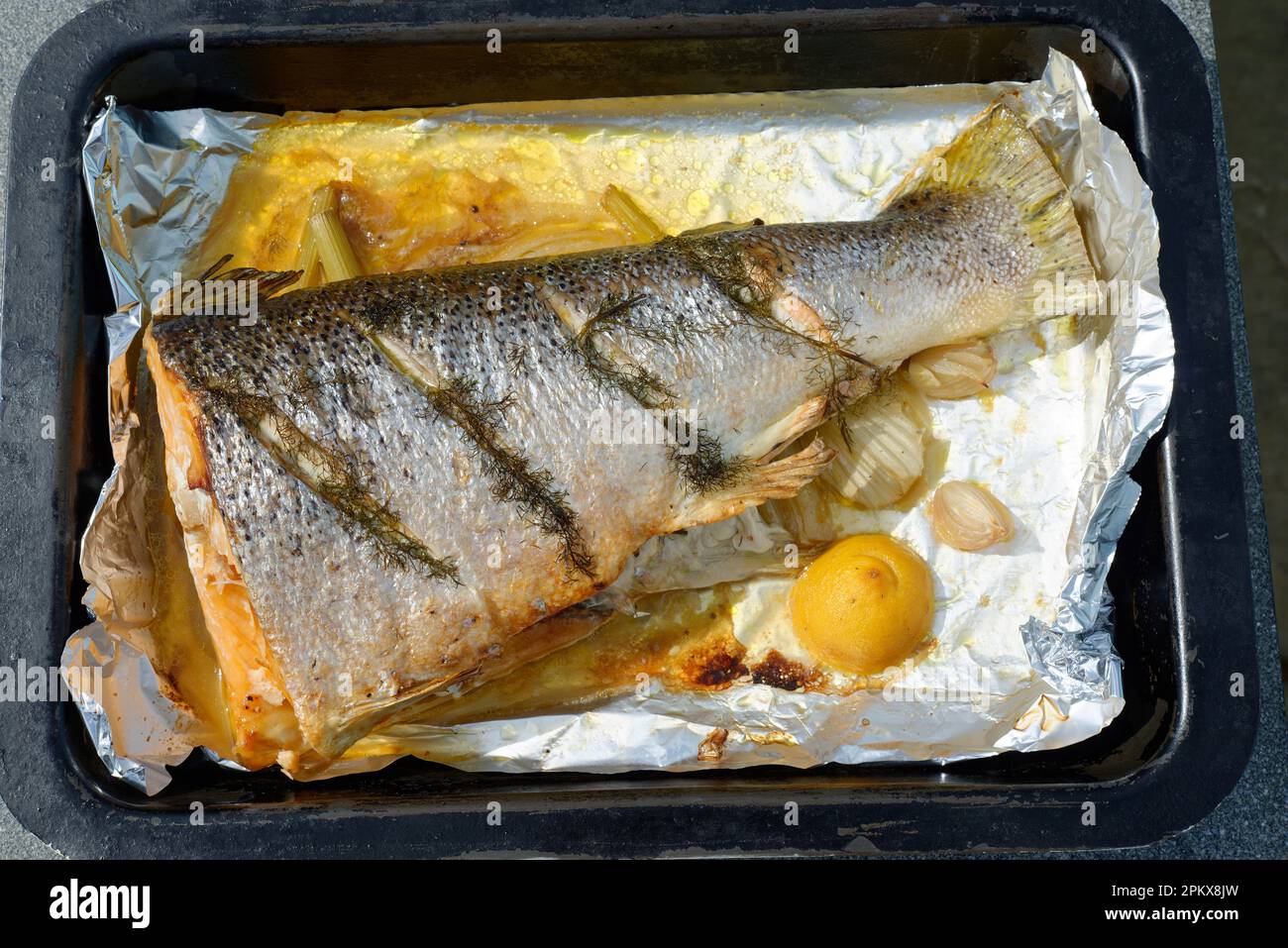 A baked half salmon cooked with vegetables, garlic and lemon Stock ...