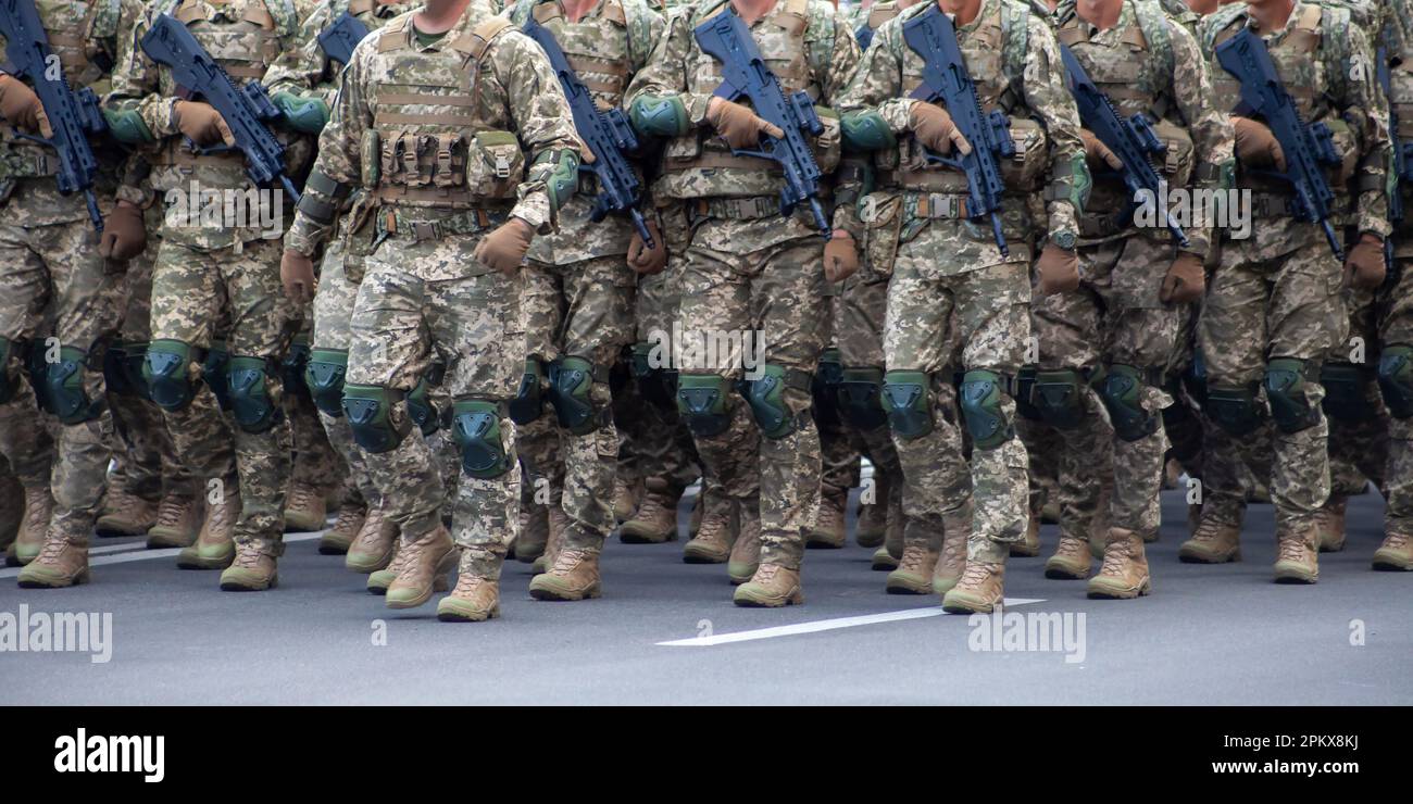 Military soldiers march in a parade with weapons. Pixel uniform ...