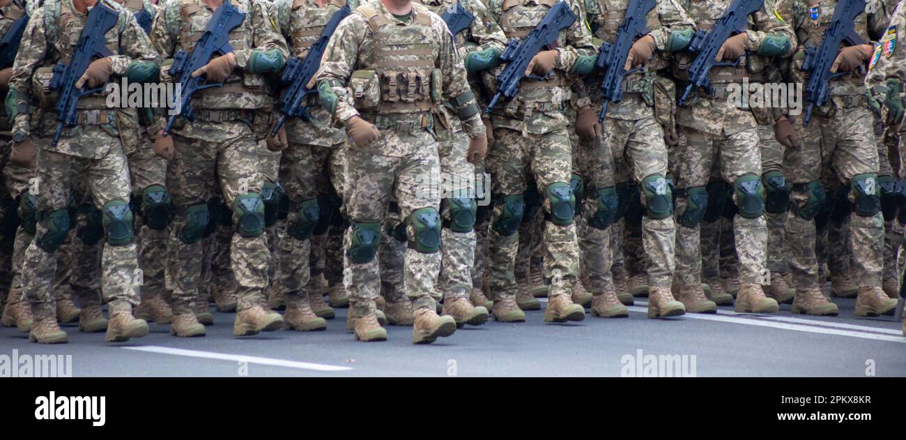 Military soldiers march in a parade with weapons. Pixel uniform ...