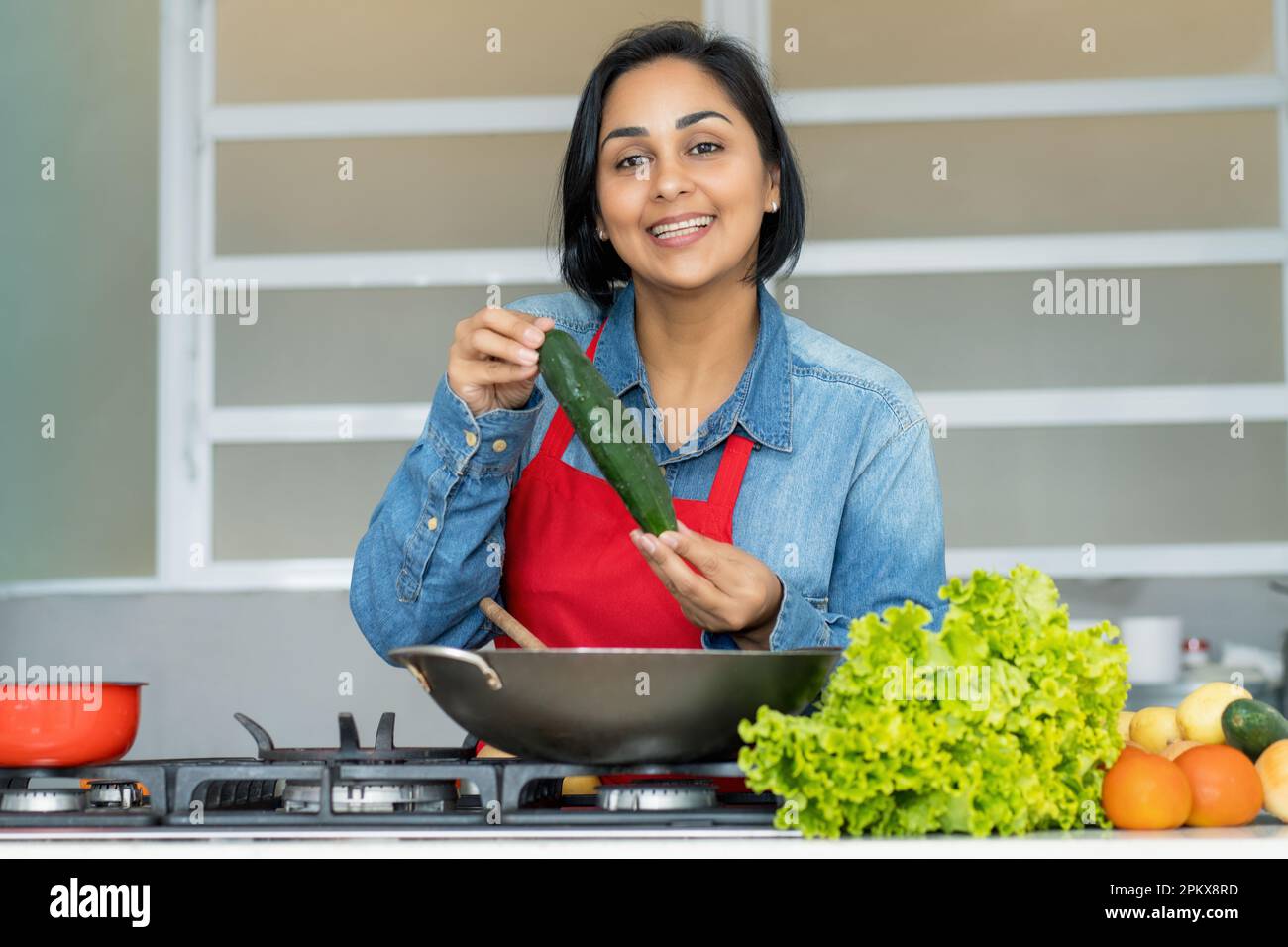 Beautiful latin american mother cooking healthy food for children at ...
