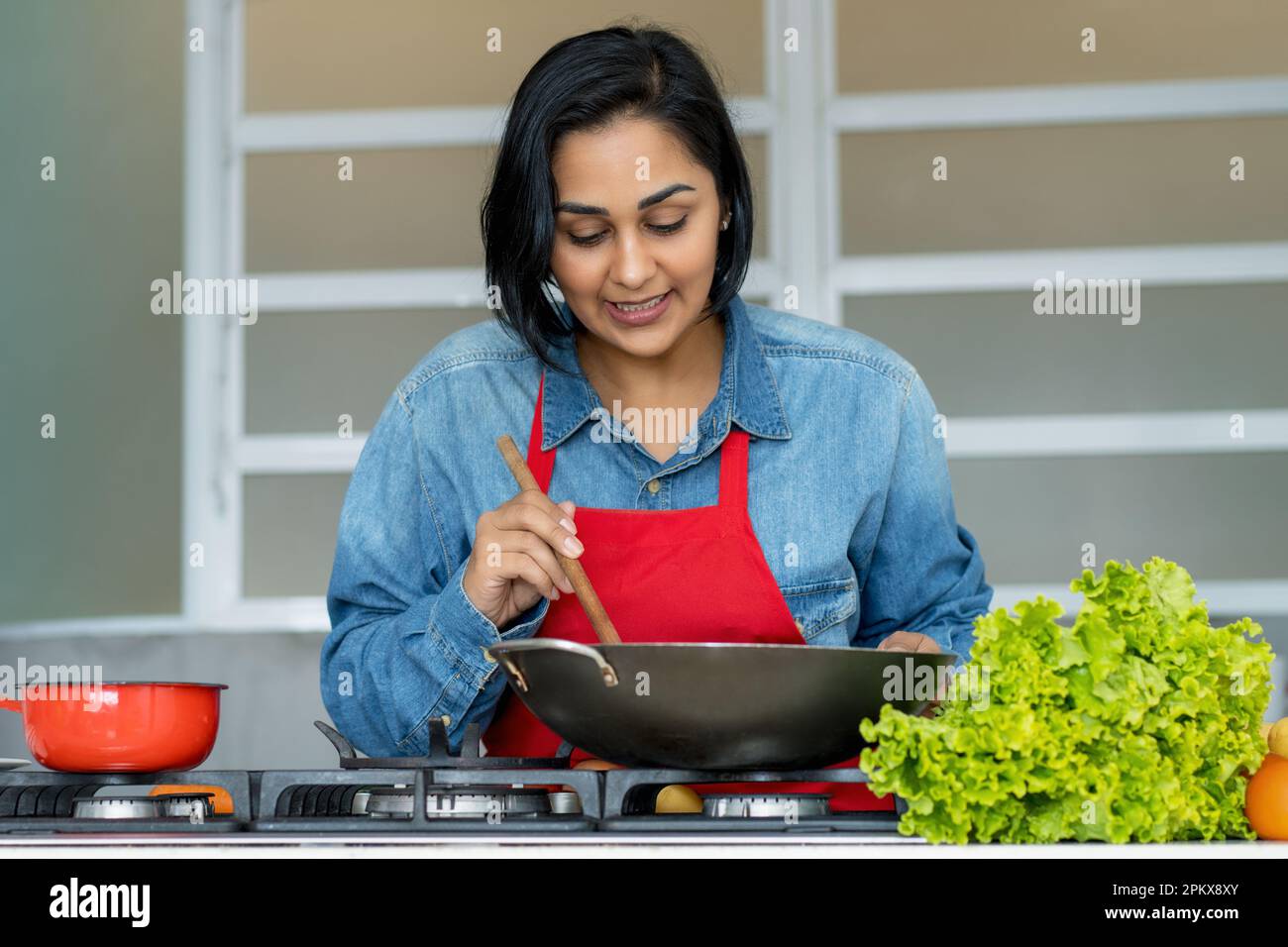 Pretty latin american woman cooking healthy food at kitchen Stock Photo ...