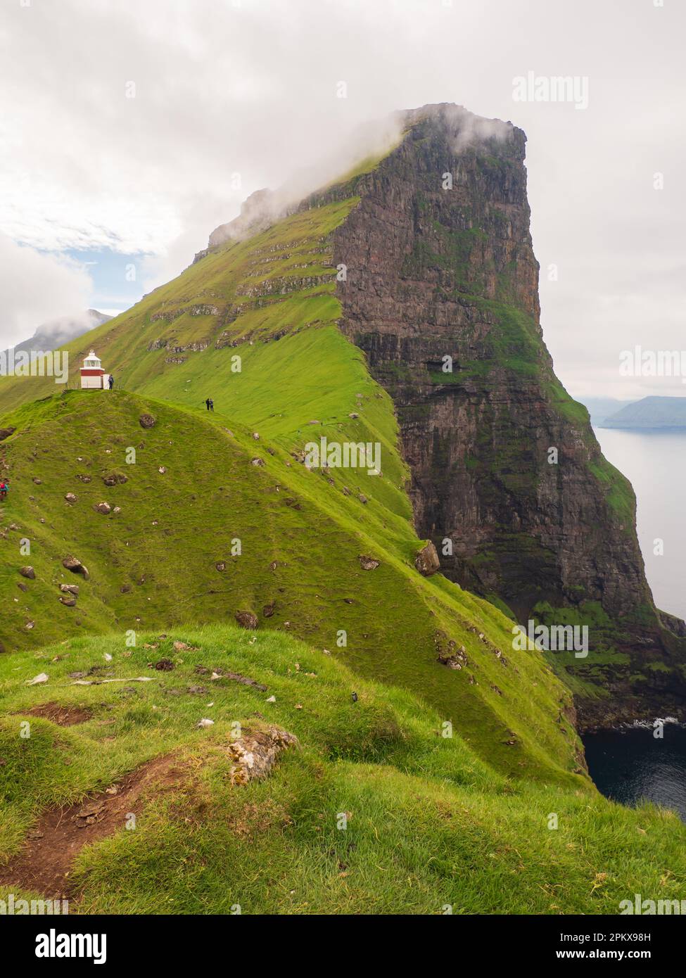 Beautiful view on Kallur lighthouse on the cliffs on the Kalsoy Island ...