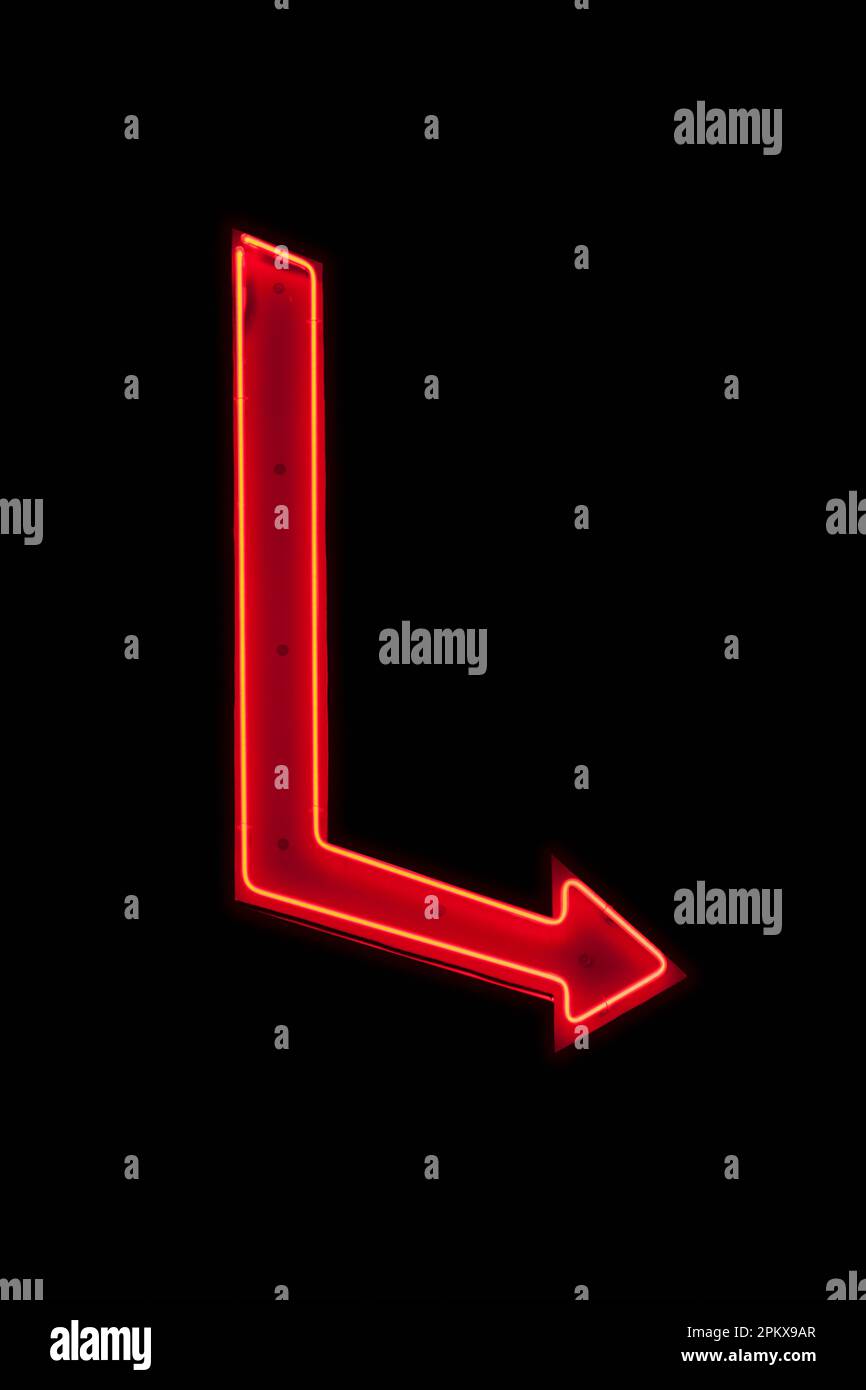 Red neon light shaped into an arrow turning right isolated on a black ...